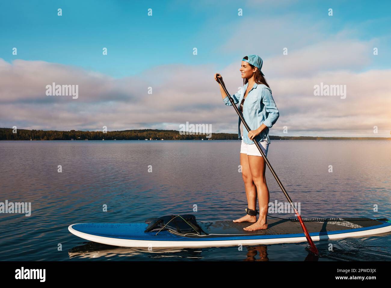 Theres so much to see out here. a young woman paddle boarding on a lake ...
