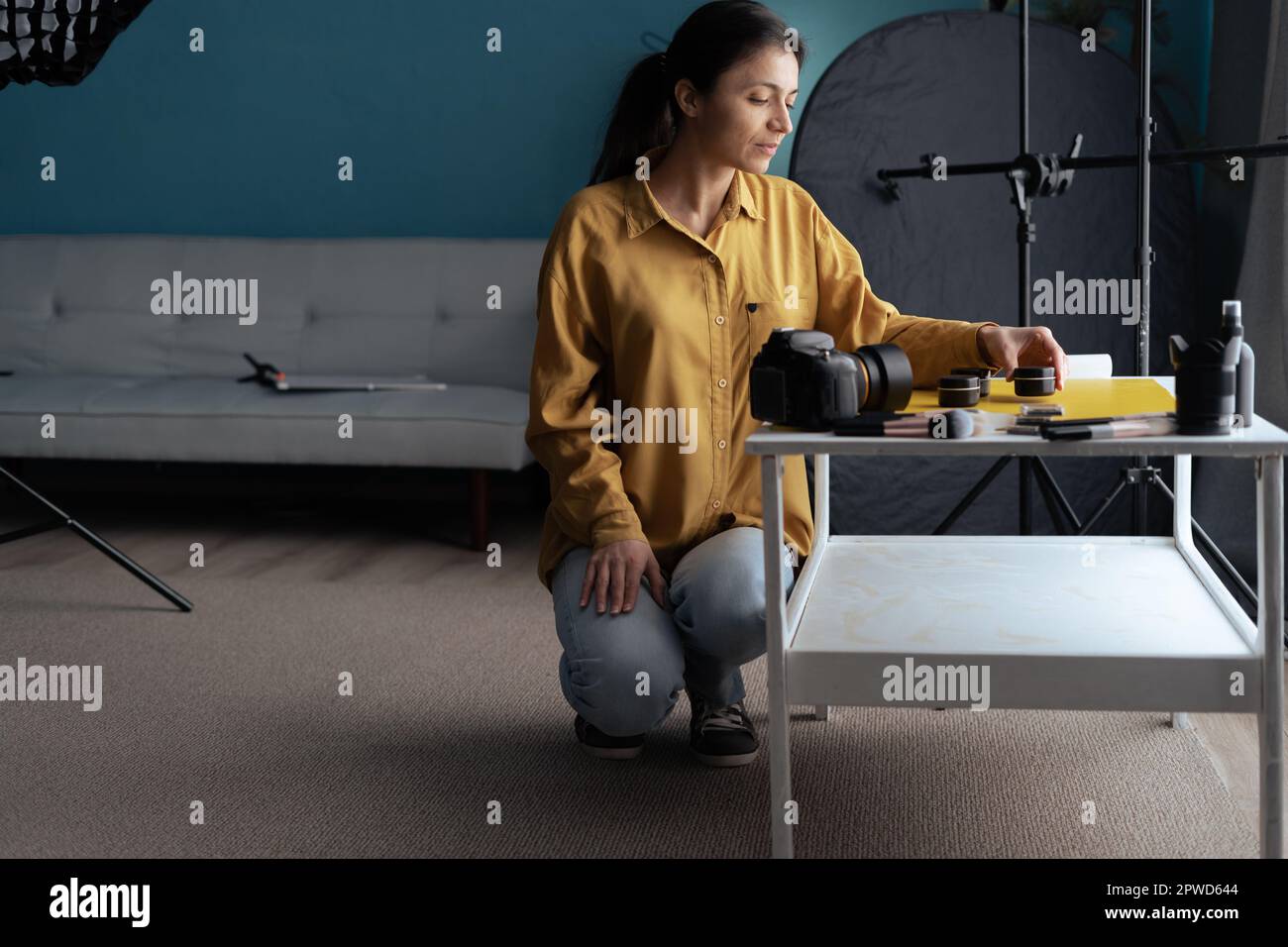 Joyful professional photographer lady preparing for shooting beauty ...