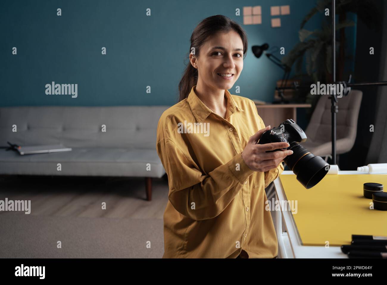 Professional photographer woman holding photo camera posing smiling to ...