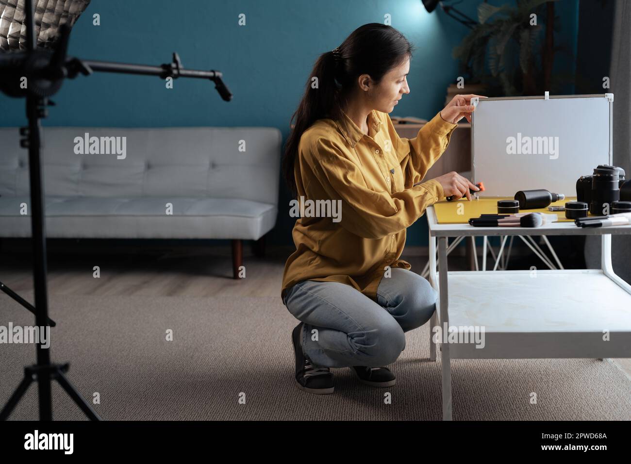 Female photographer preparing for the shooting laying out props on the ...