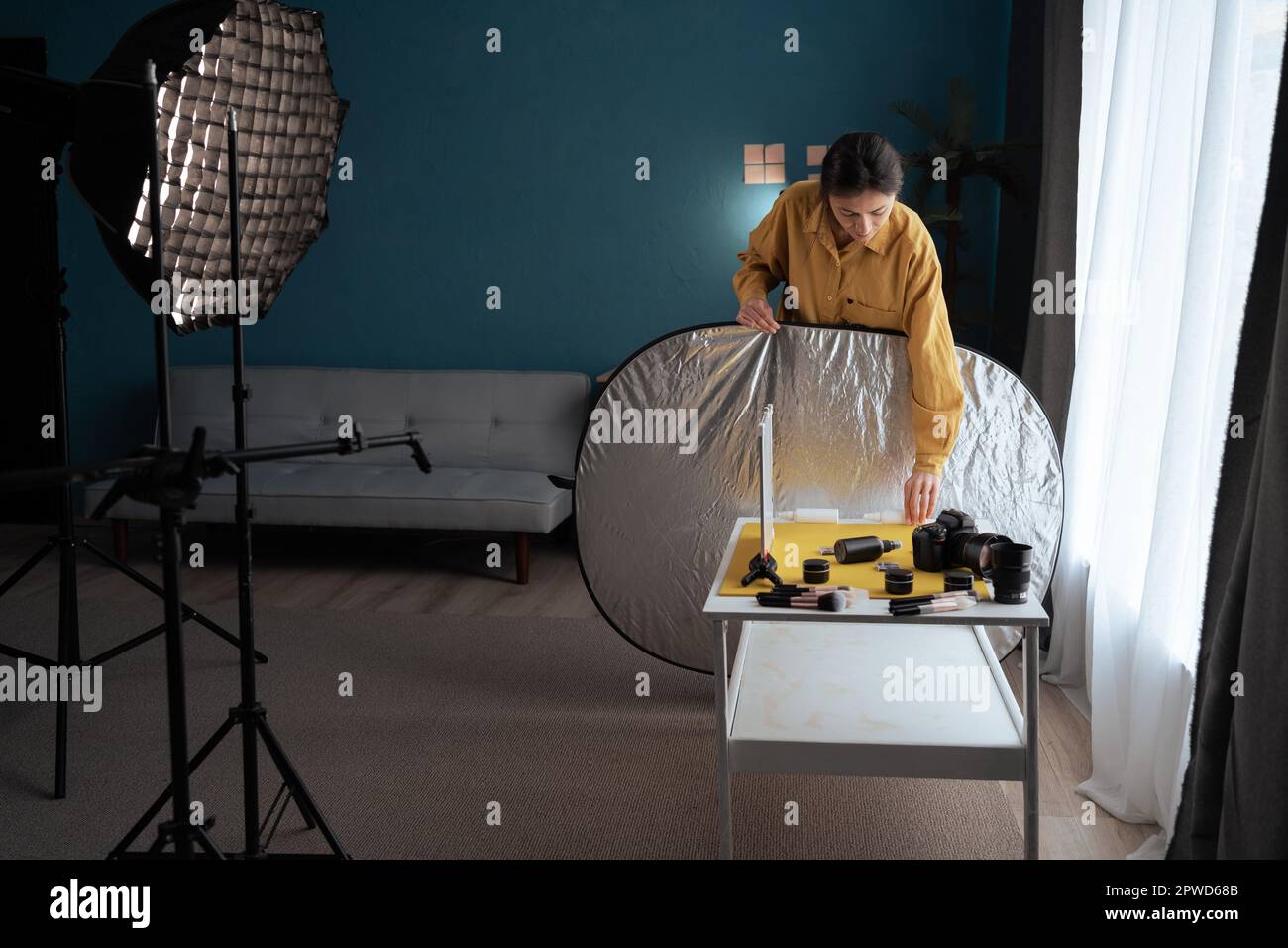 Female photographer in an equipped photo studio is preparing for the ...