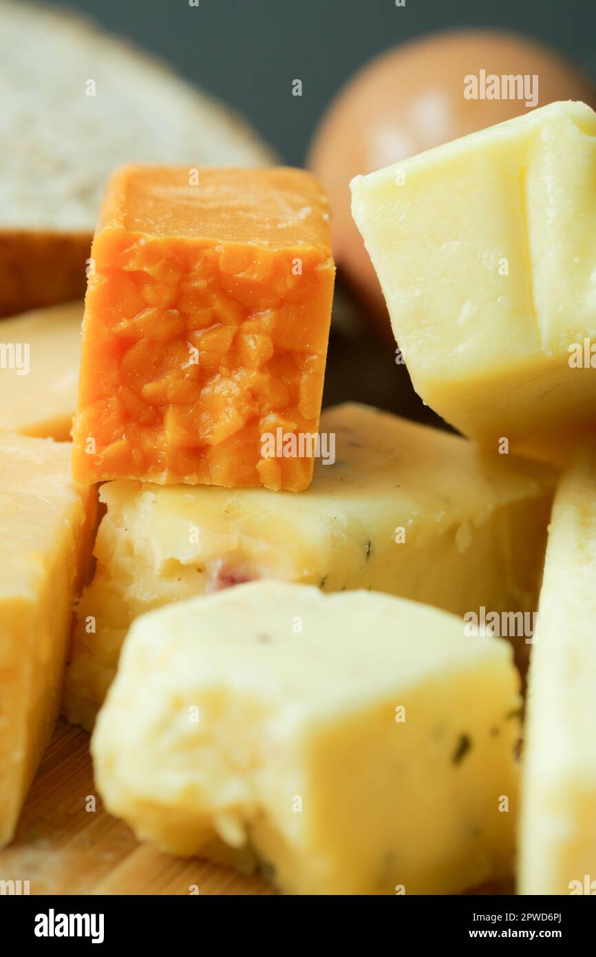 Cheese cubes green, yellow and red color on chopping board Stock Photo ...