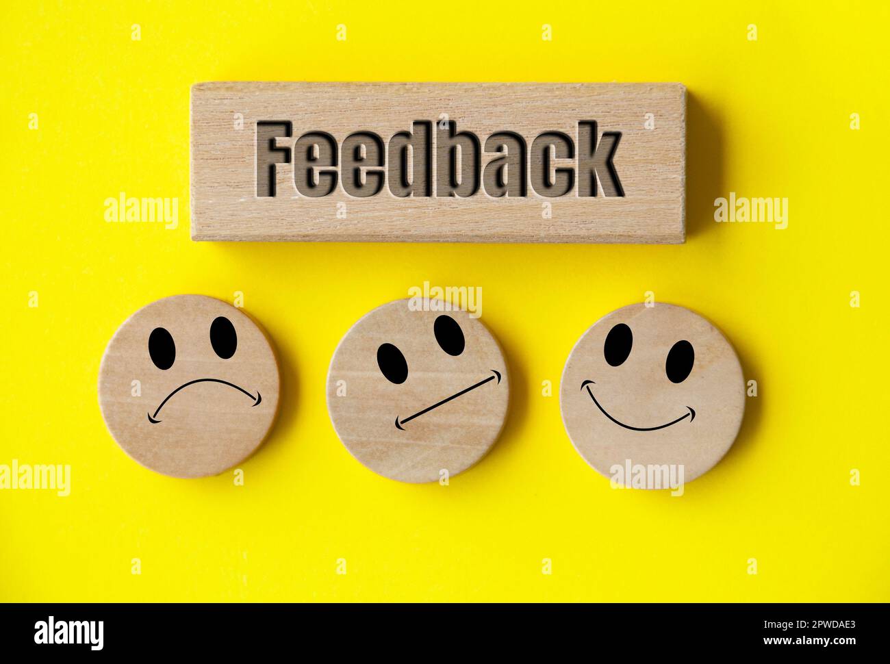 Feedback text on wooden block with happy, sad and neutral emoticon ...