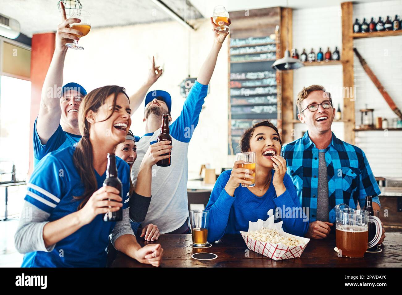 Big fun watching the big game. a group of friends cheering while ...