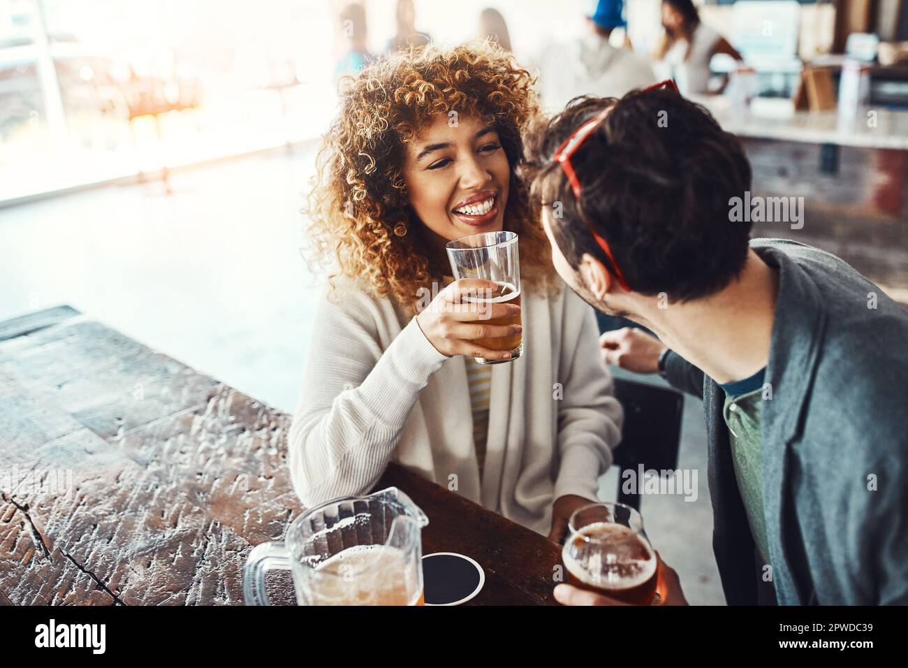Tell me more about yourself. a happy young man and woman having beers ...