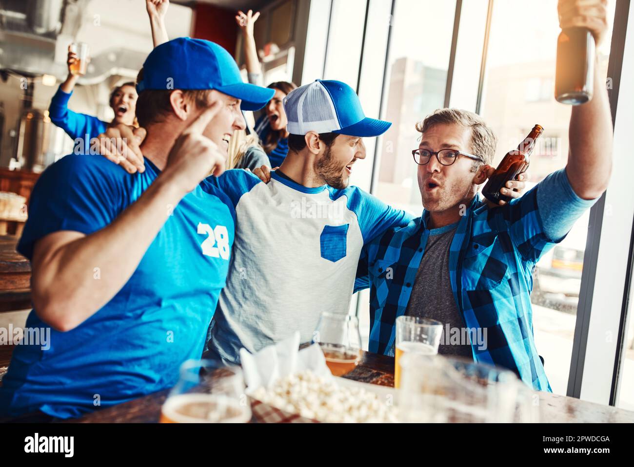 Woohoo to another win. a group of friends cheering while watching a ...