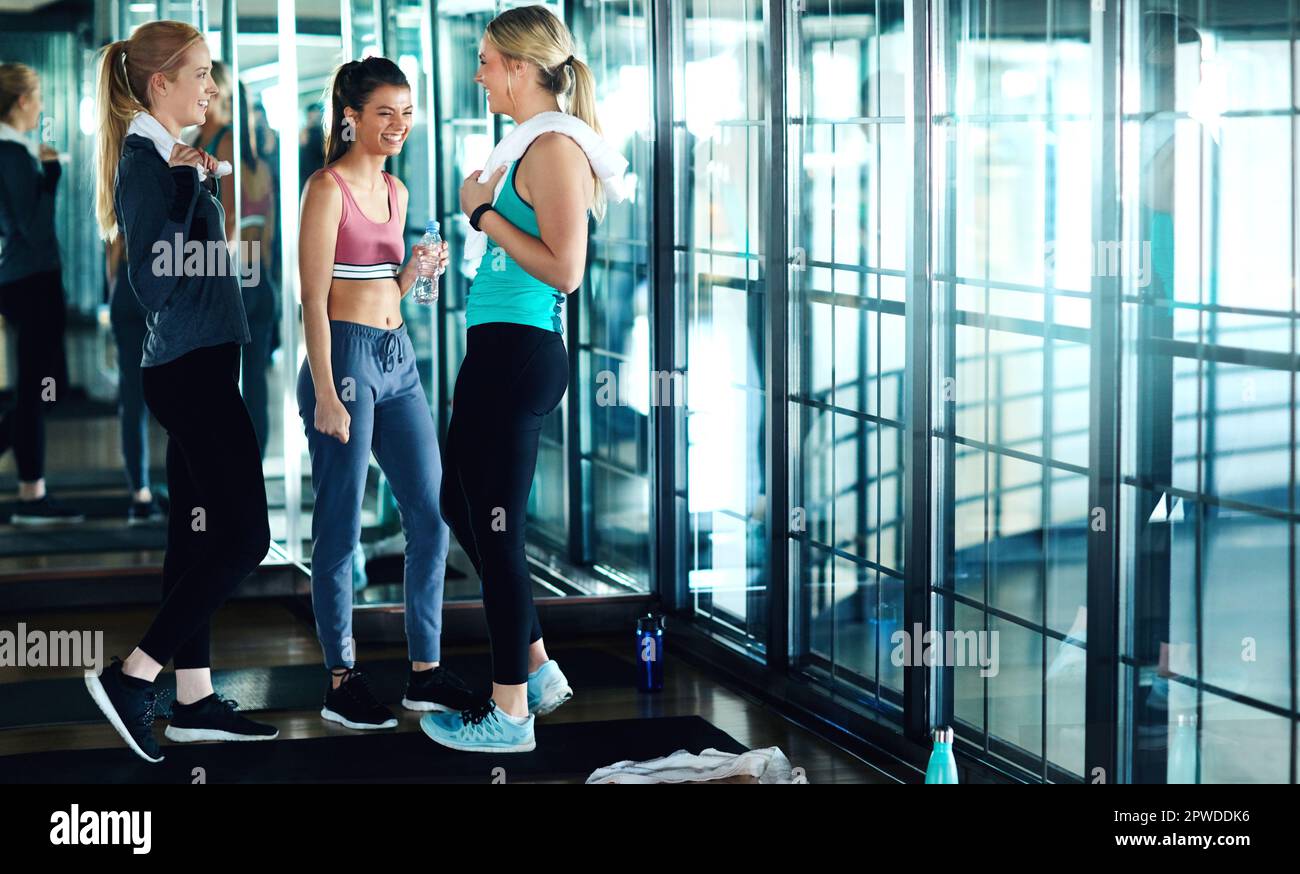 Catching up after their workout. three attractive young women taking a ...