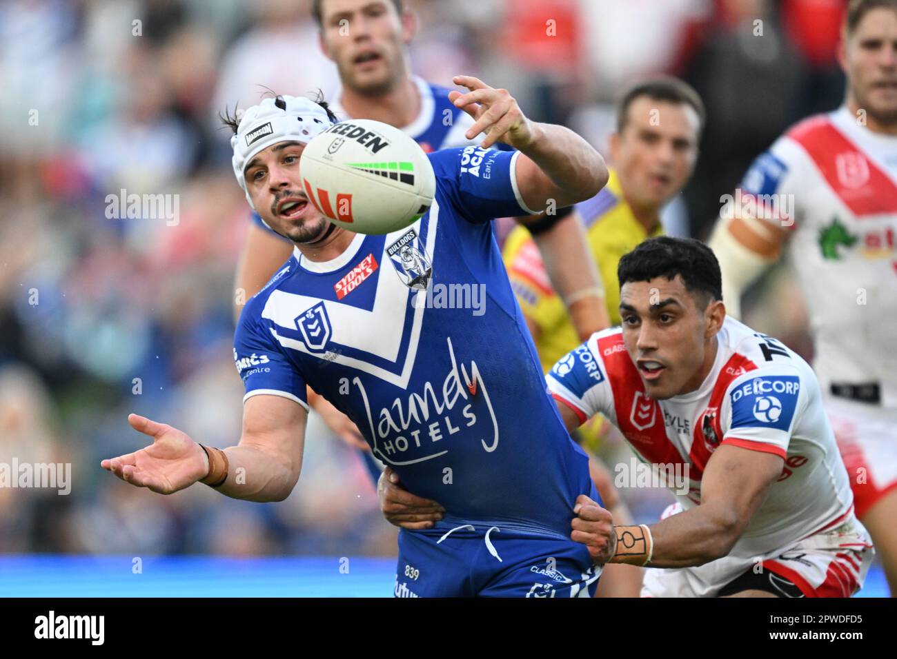Reed Mahoney of the Bulldogs offloads the ball as he’s tackled by ...