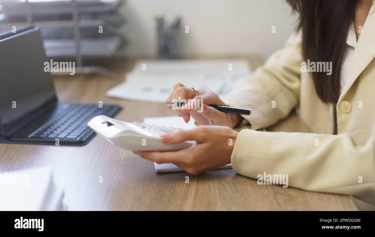 Secretary concept, Female secretary using calculator to calculate ...