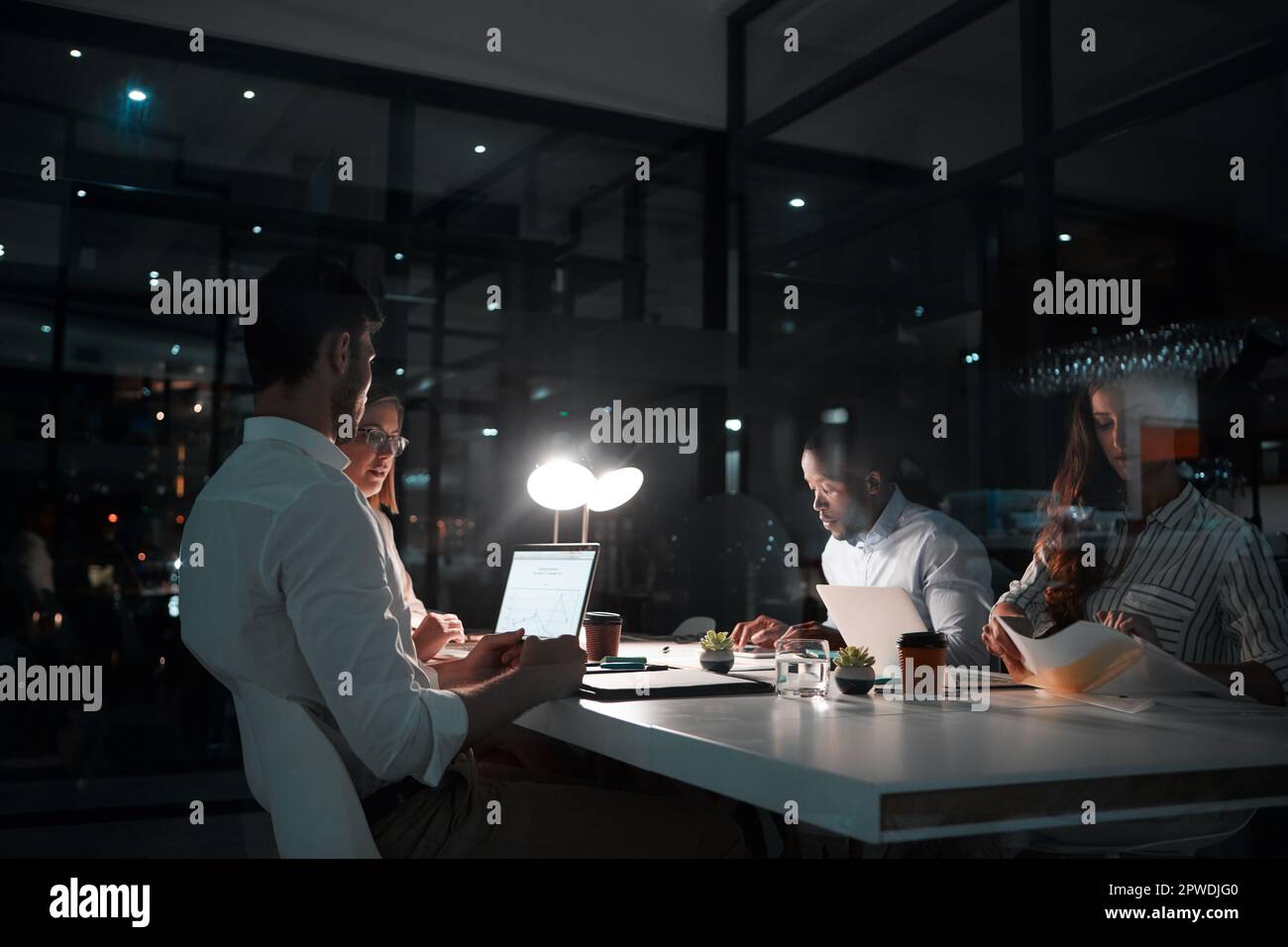 Work comes first. colleagues having a meeting during a late night in a ...