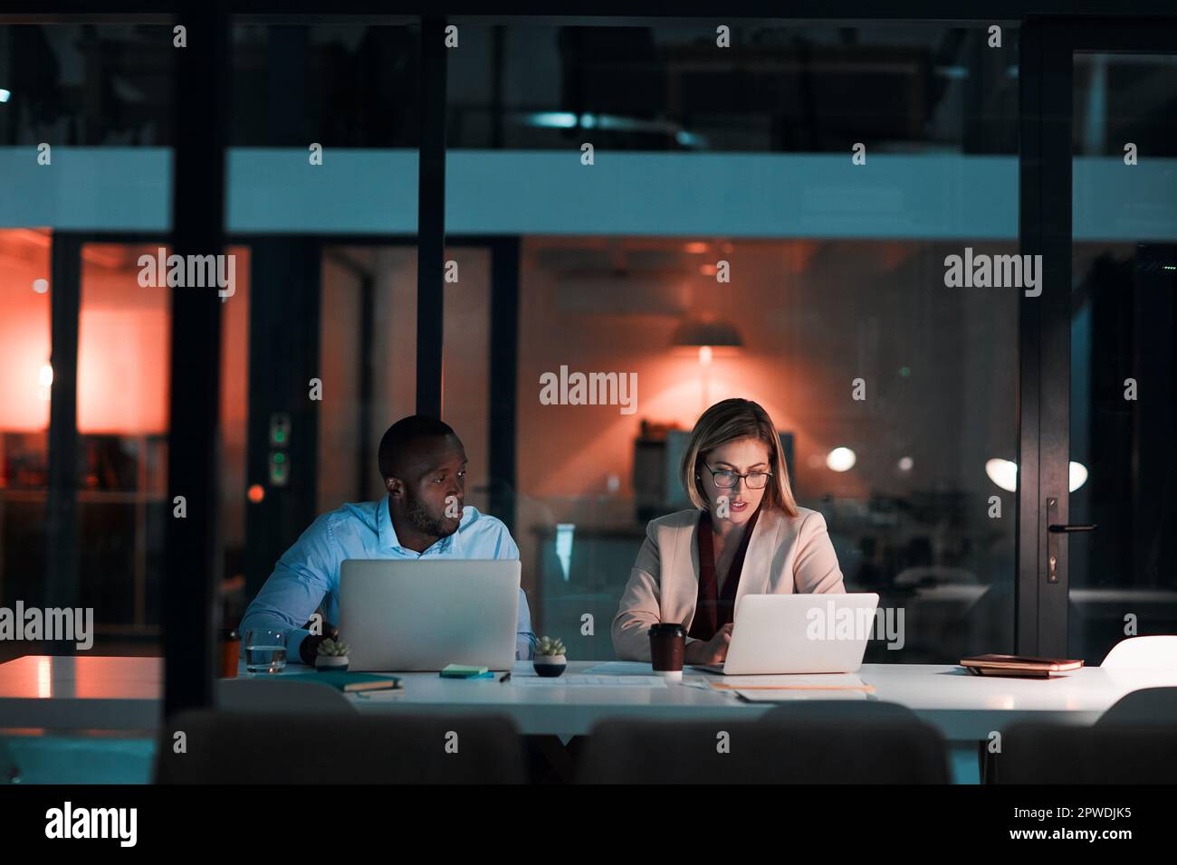 Making the night count. two colleagues using their laptops during a ...