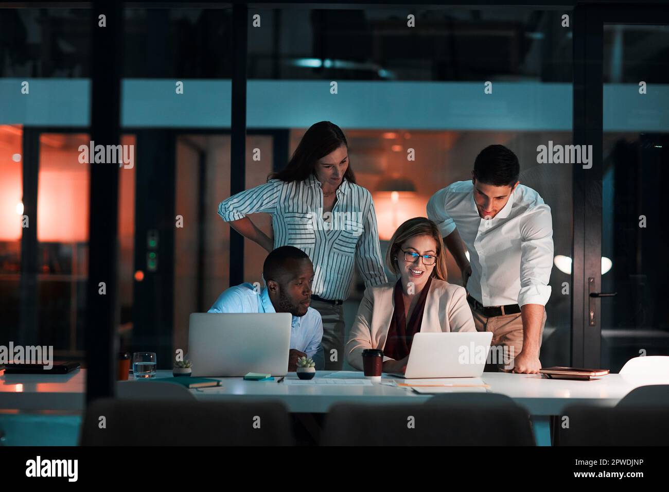 Working late and working hard. colleagues using a laptop together ...