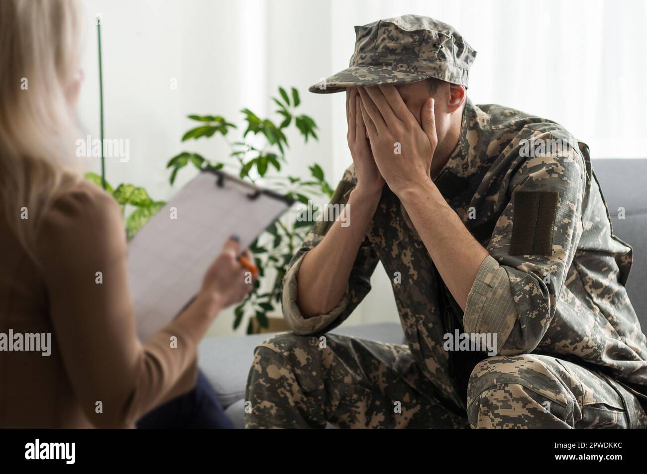 sad soldier with ptsd talking at psychiatrist and gesturing while ...