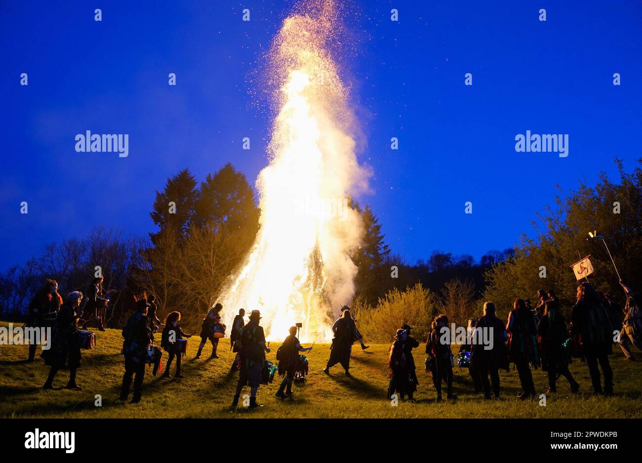Members of the Pentacle Drummers perform in front of a burning wicker ...