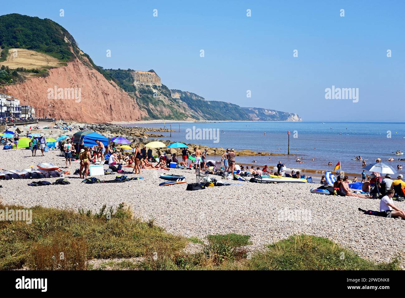 Tourists relaxing on the beach with views towards town buildings and ...