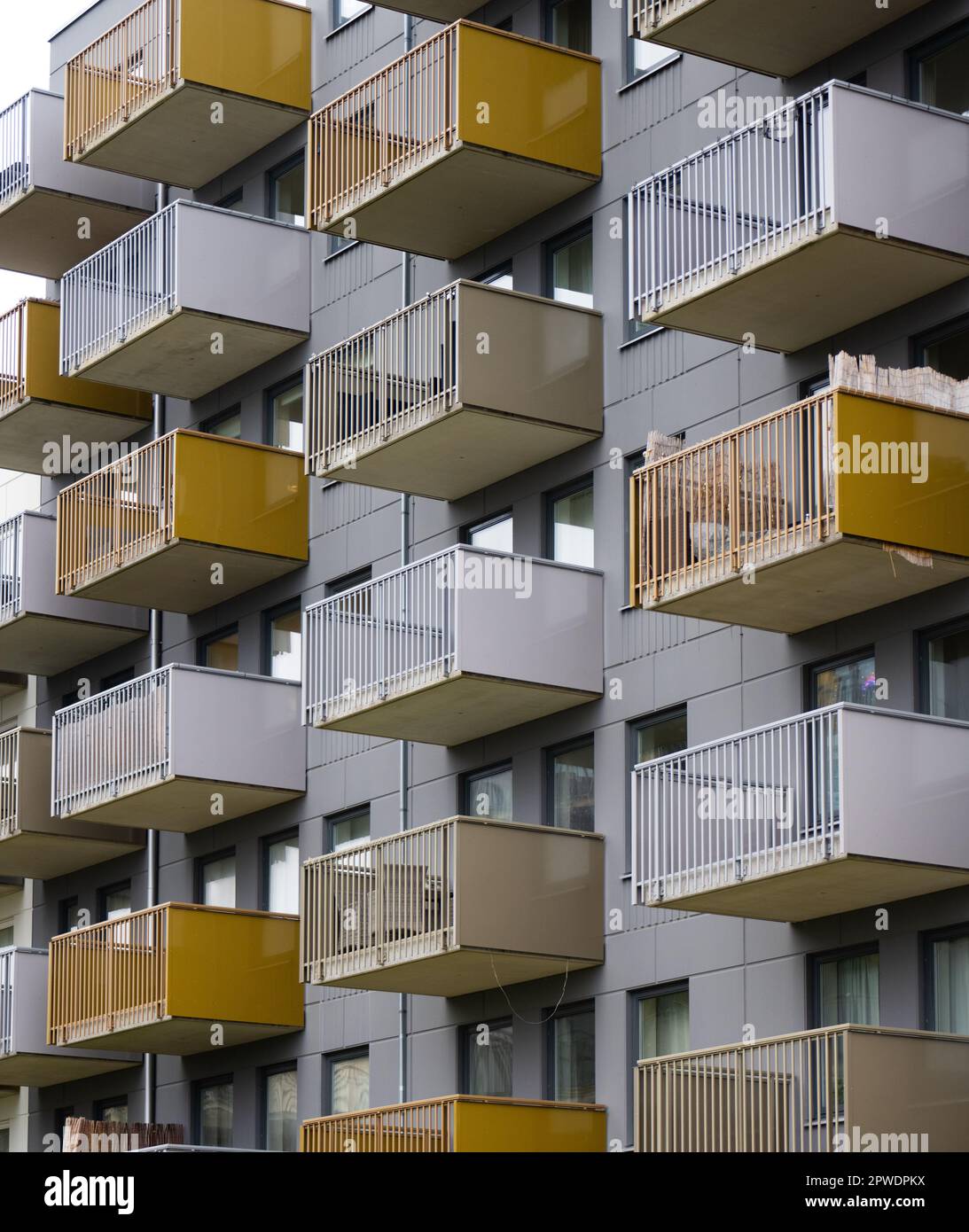Grey tall apartment building with white and golden balconies Stock ...