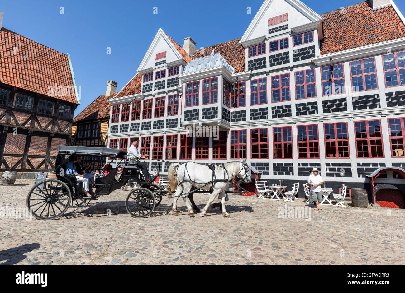Horse and carriage with people by half timbered historic buildings in ...