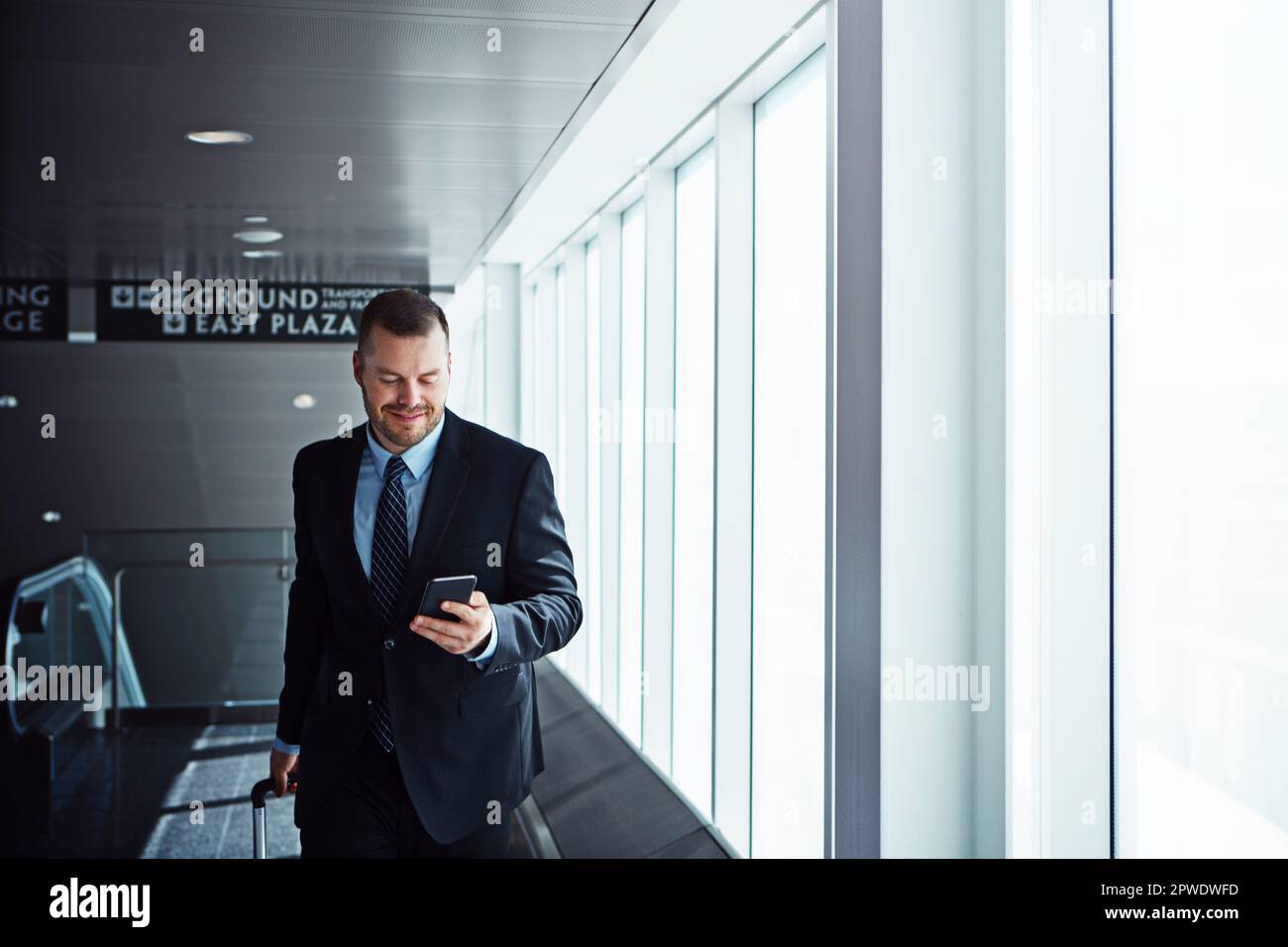 Checking in before taking off. an executive businessman walking through ...