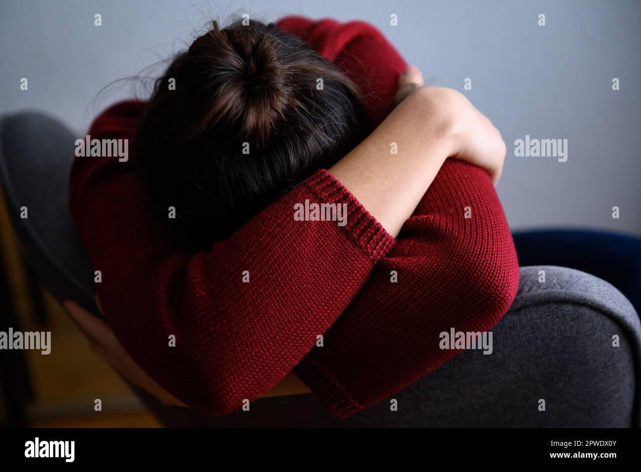 Hamburg, Germany. 18th Feb, 2023. A woman sits on a chair with her head ...