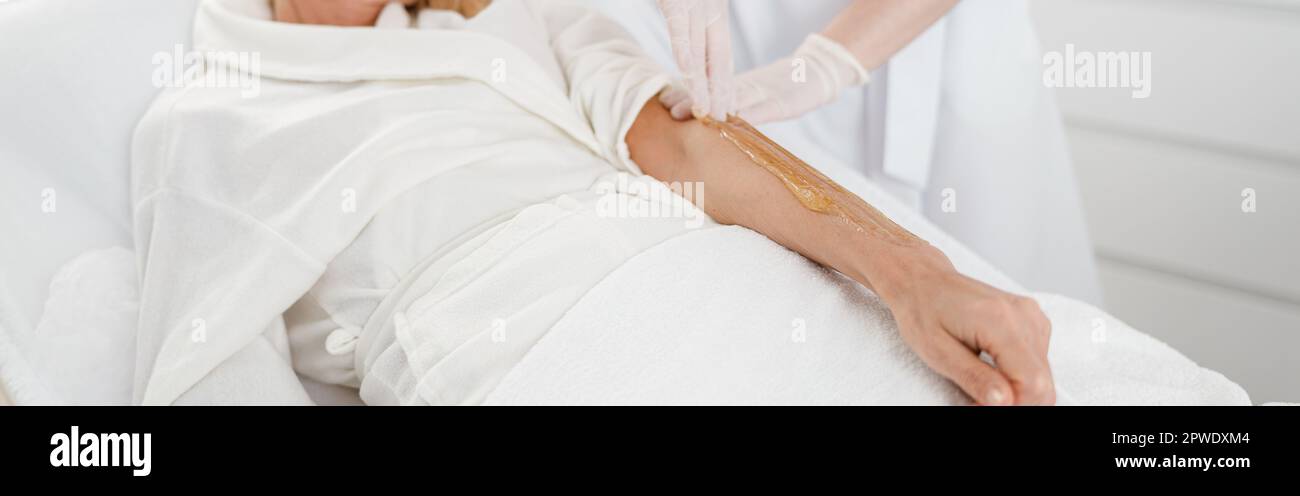 Professional doing hair sugaring hi-res stock photography and images ...