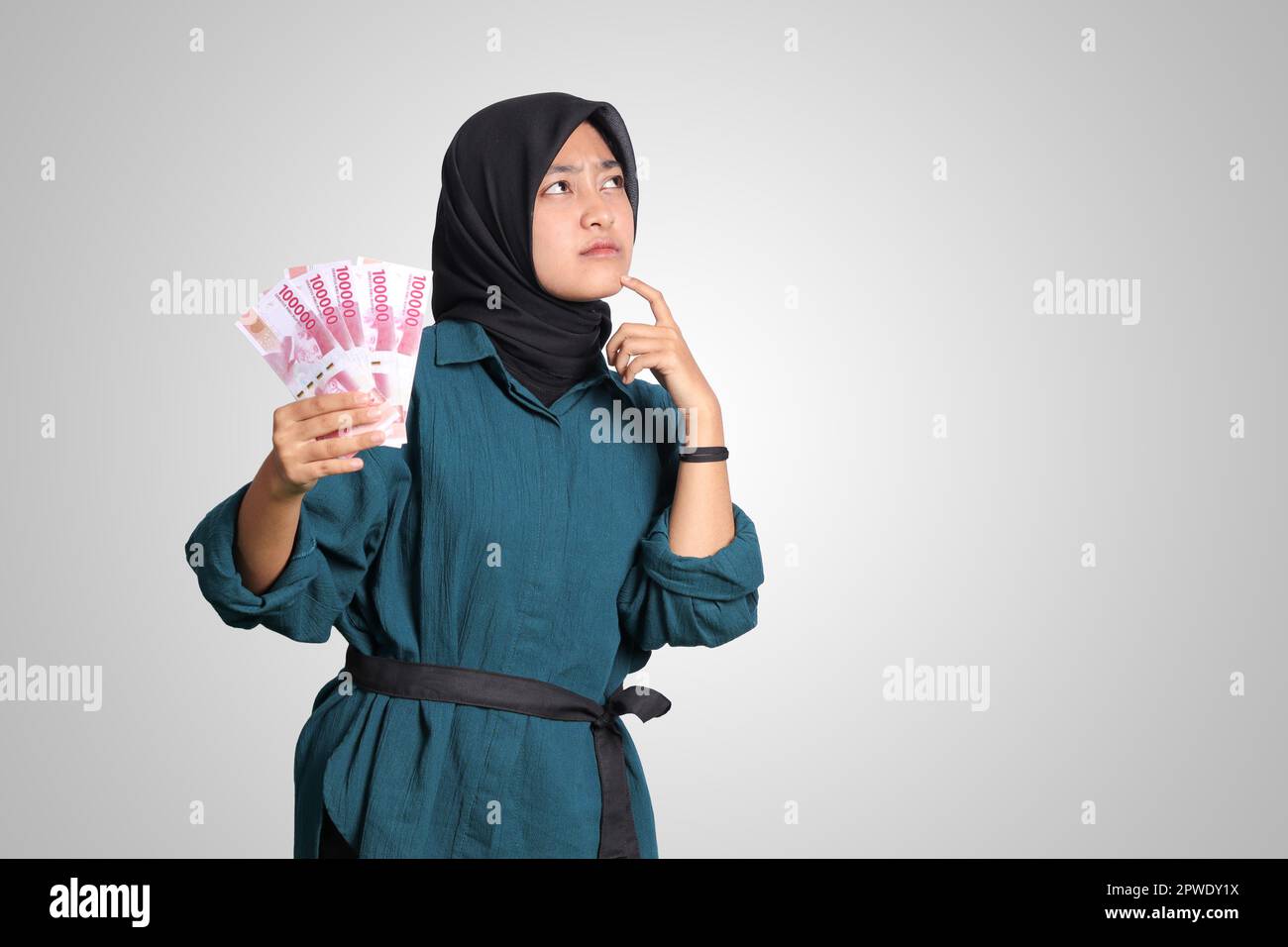 Portrait of confused Asian hijab woman in casual outfit showing one ...