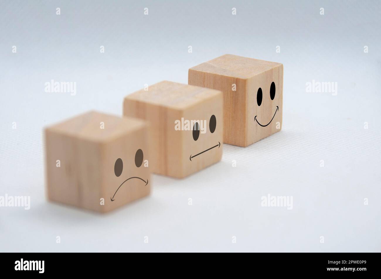 Sad, neutral and happy emoticon faces on wooden cubes with white ...