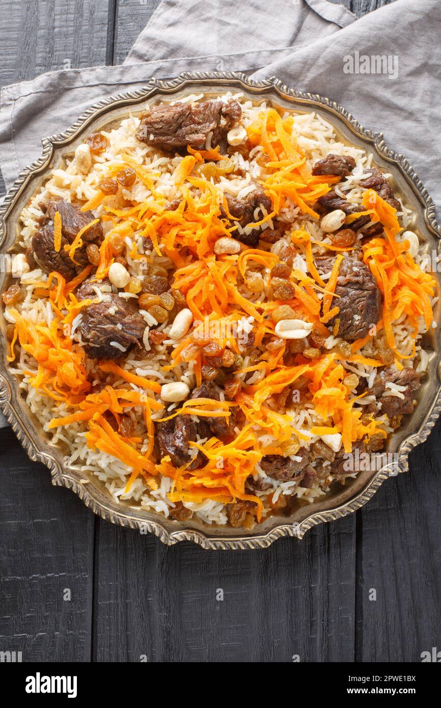 Traditional Kabuli Pulao with Sweet Carrot and raisins topping closeup ...