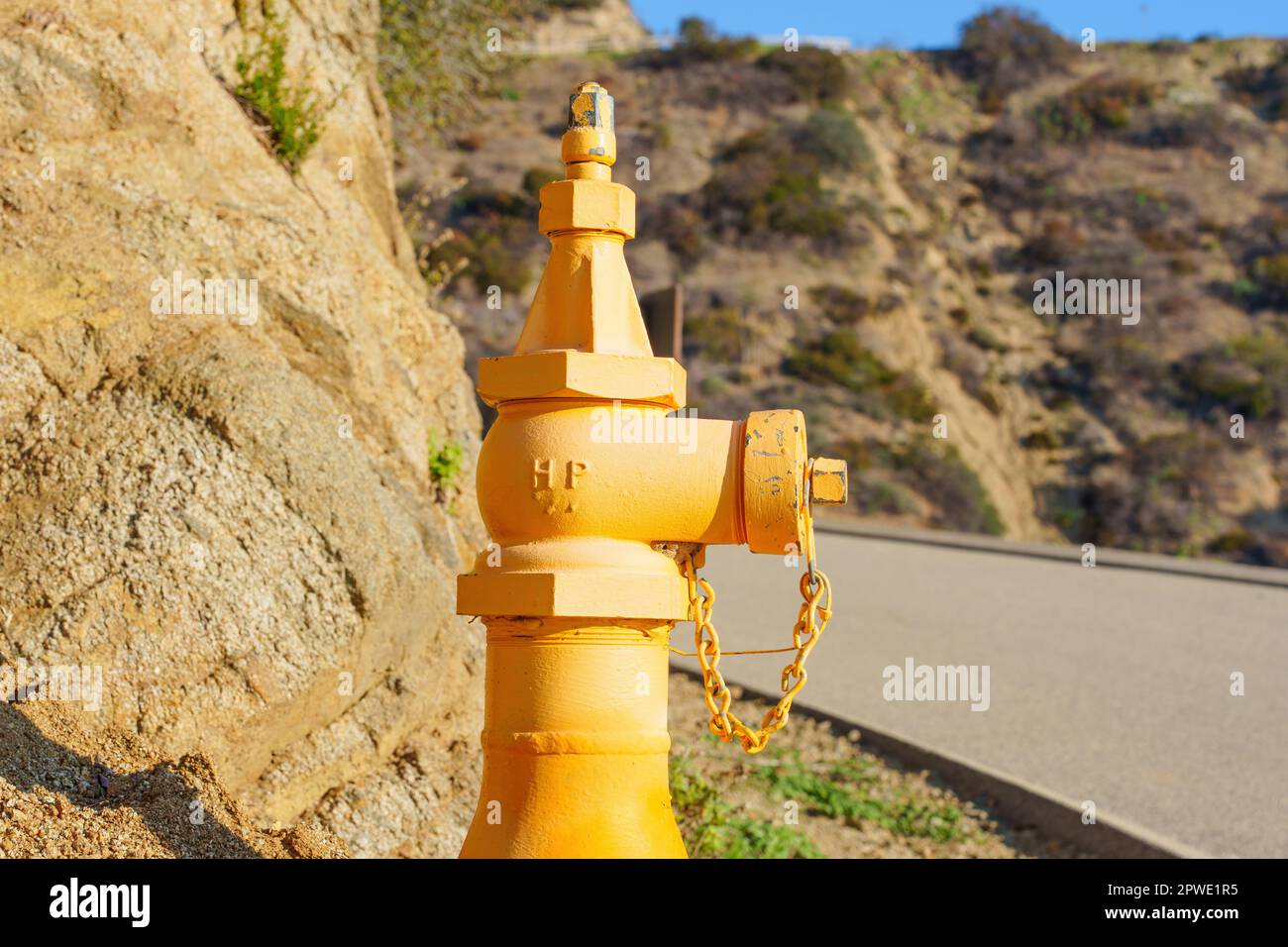 Close-up view of a yellow fire hydrant by a paved fire road in Runyon ...