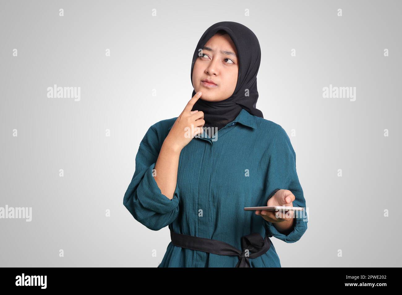 Portrait of confused Asian muslim woman with hijab showing ok hand ...