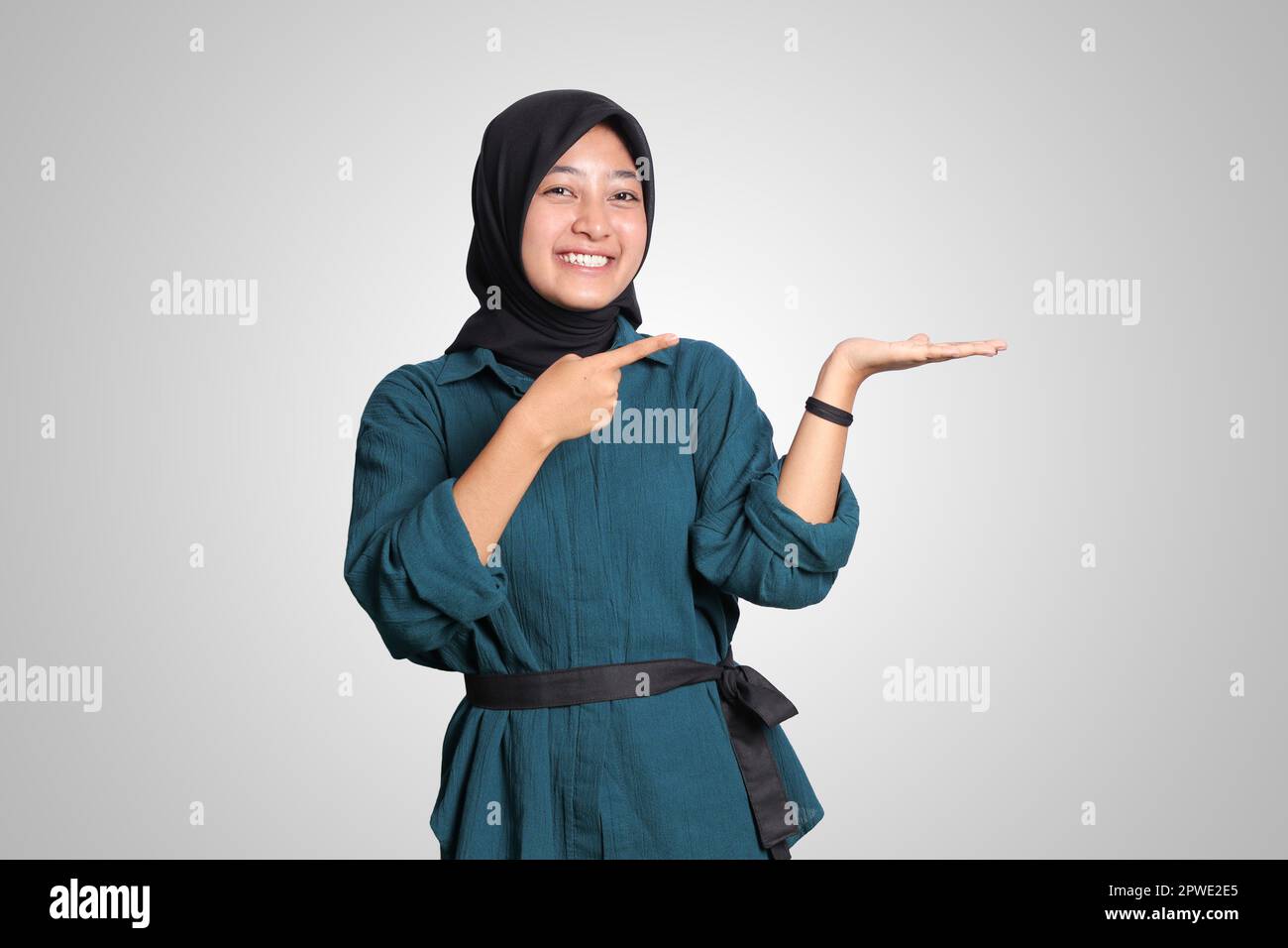 Portrait of excited Asian hijab woman in casual outfit standing against ...
