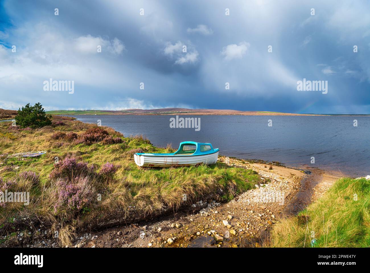 A boat on the shores of Carrowmore Lake at County Mayo in the west of ...
