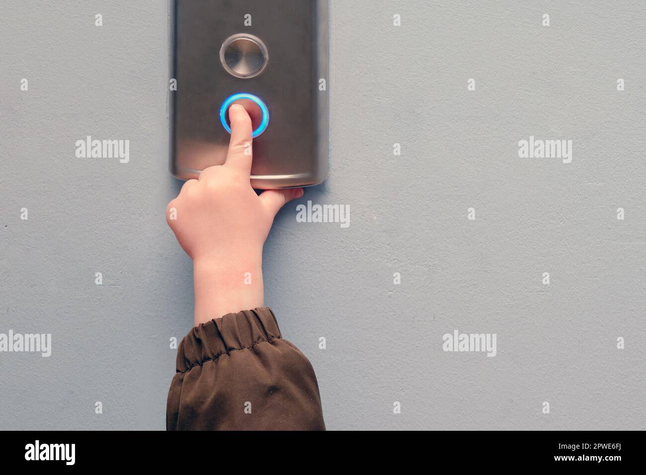 A small child presses the elevator call button. Baby reaches for the ...