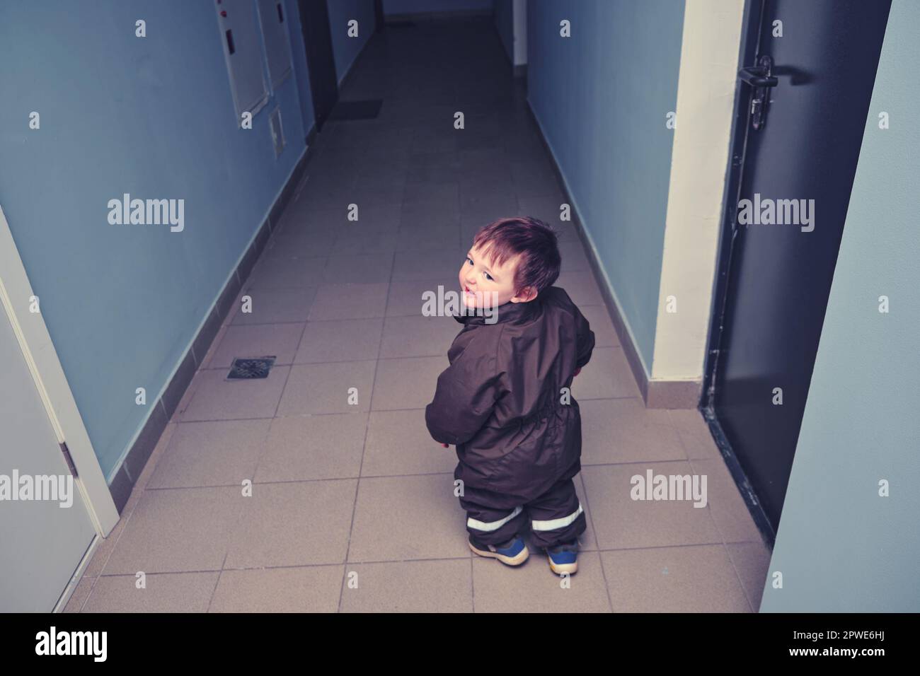 A child walks down the corridor of an apartment building. Baby comes ...