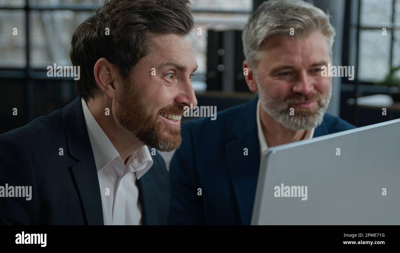 Close-up two surprised caucasian men different ages businessmen ...