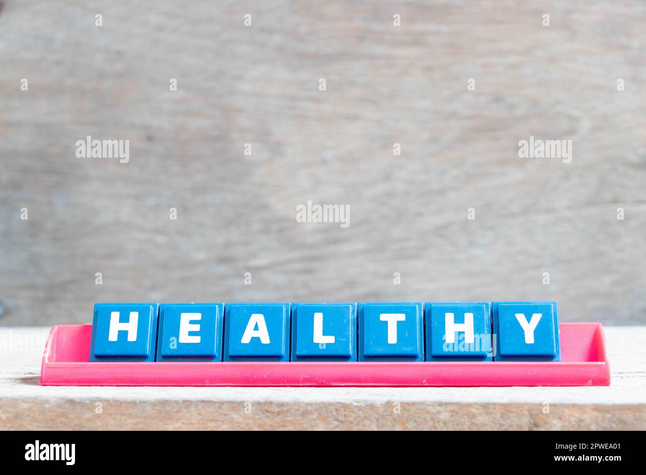 Tile alphabet letter with word healthy in red color rack on wood ...
