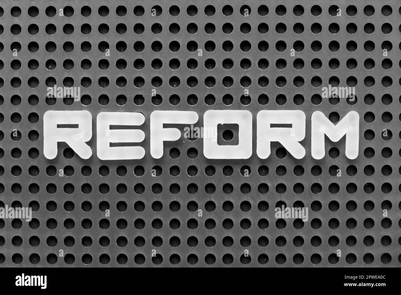 White alphabet letter in word reform on black pegboard background Stock ...