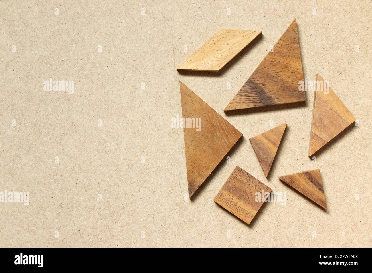 Straggled tangram puzzle wait to complete the shape on wood background ...