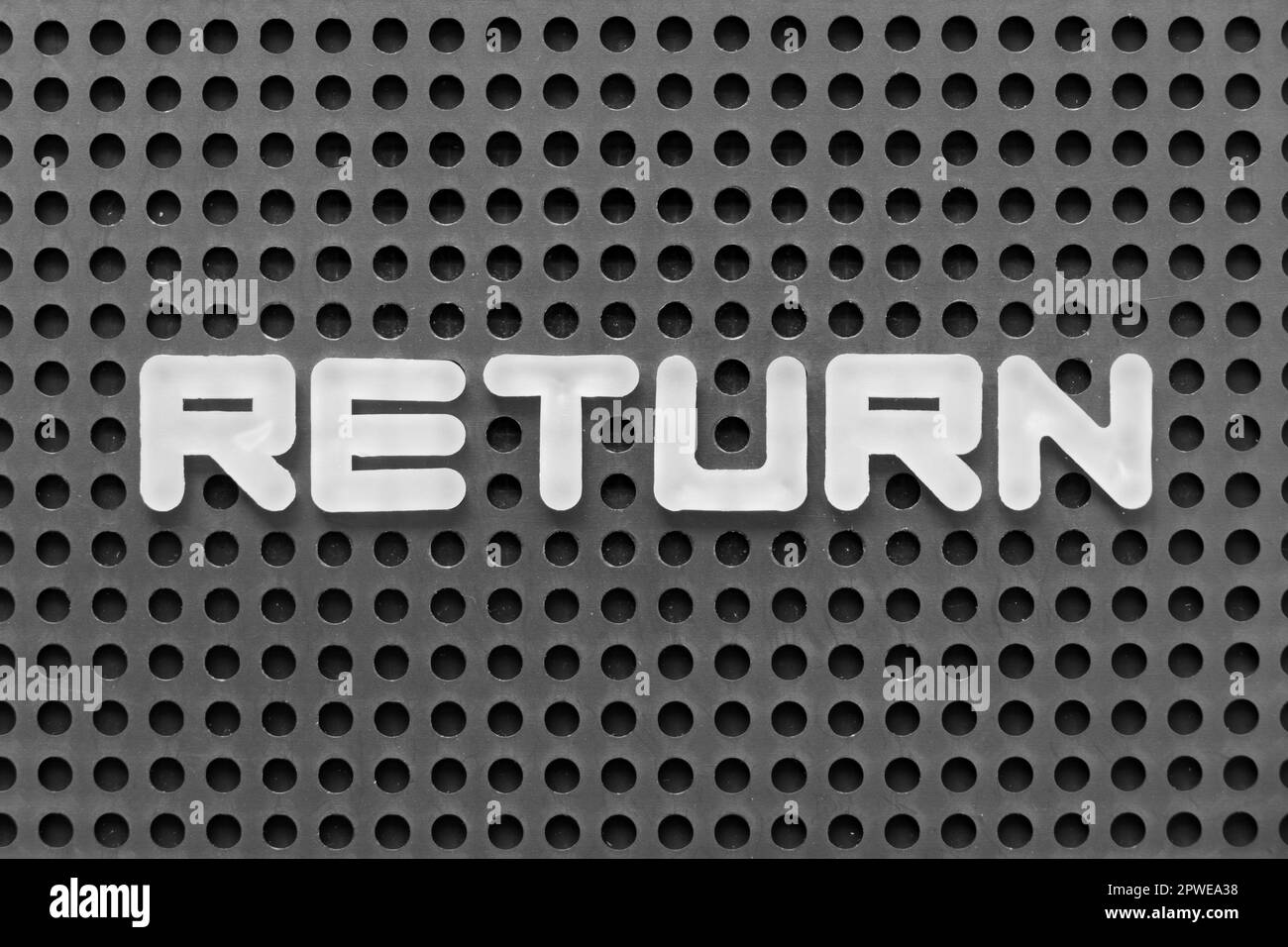 White alphabet letter in word return on black pegboard background Stock ...