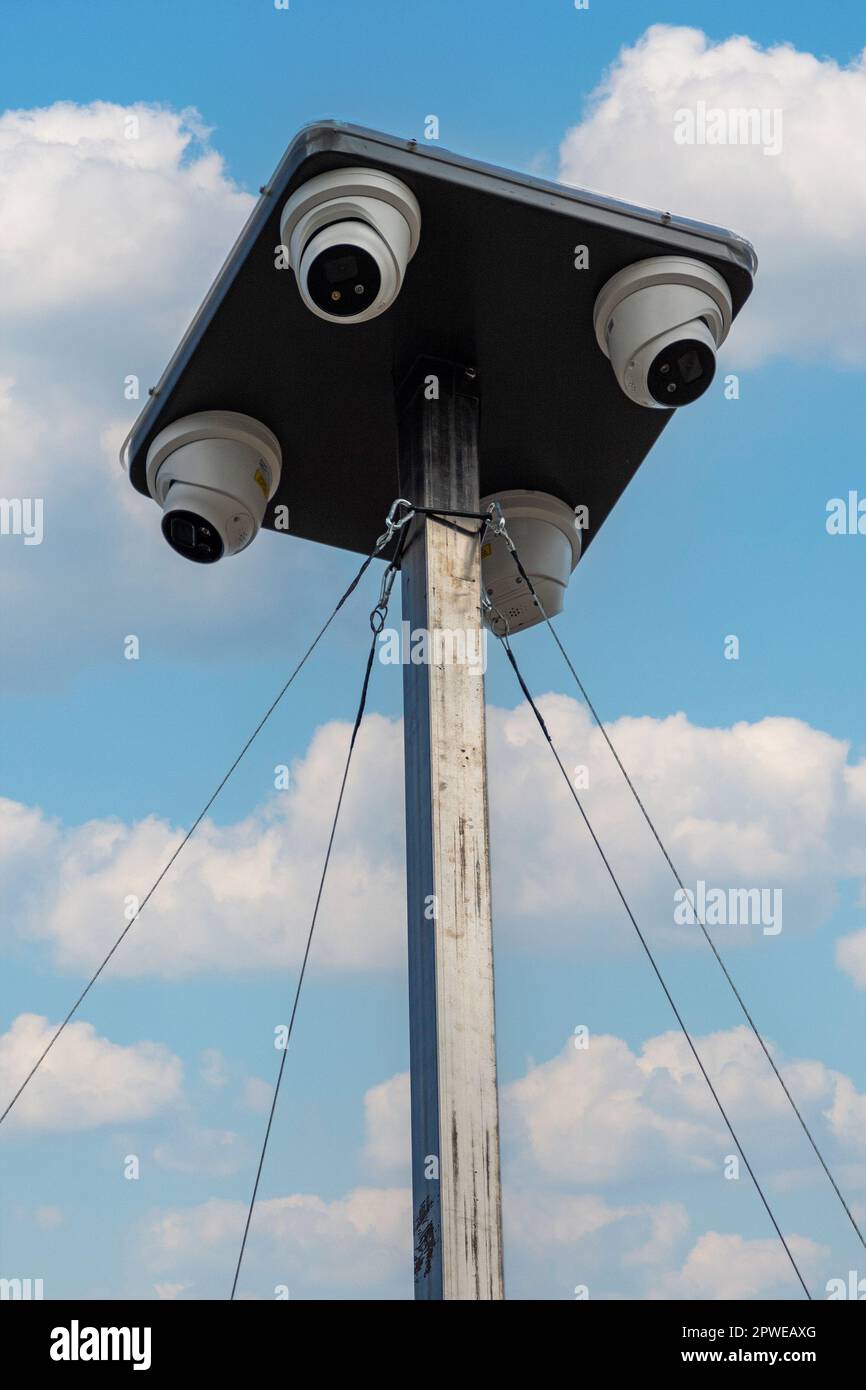 CCTV surveillance security cameras on tall pole with clouds in ...
