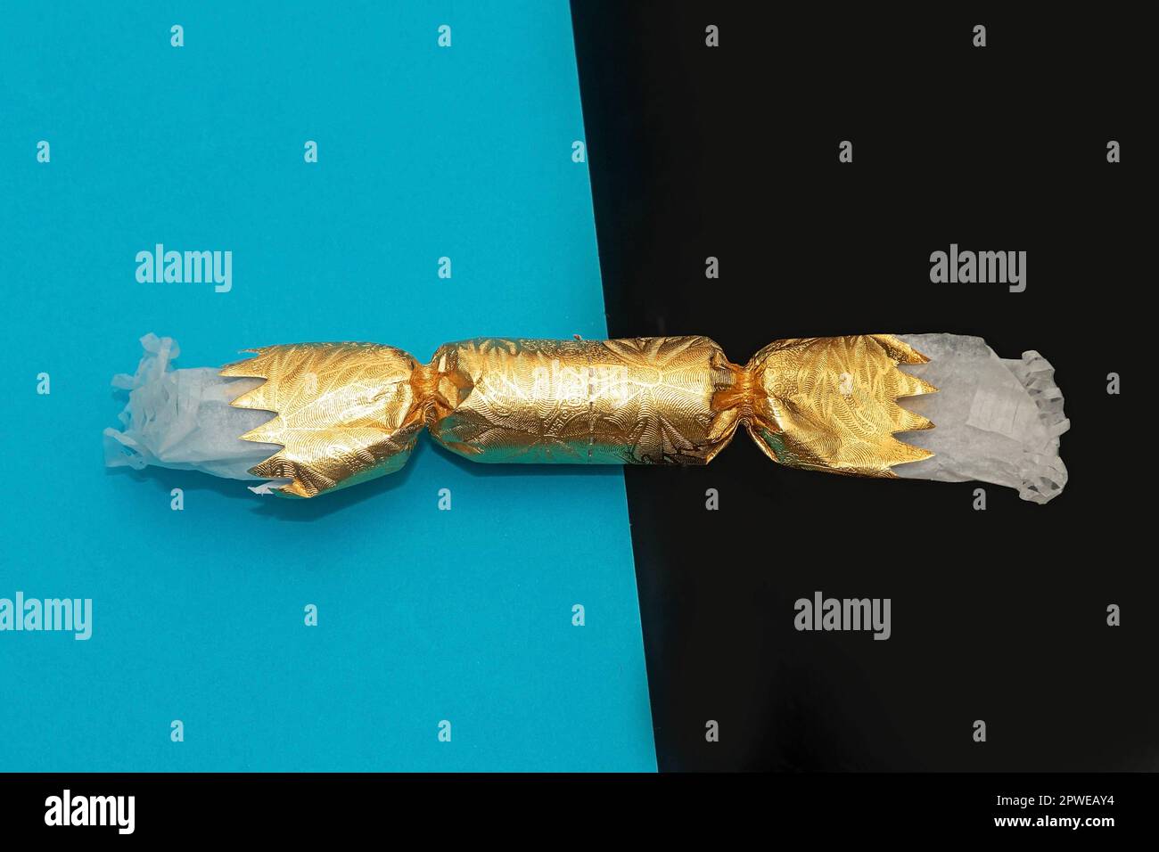 Festive Christmas fire cracker wrapped in gold paper tube on two sided ...