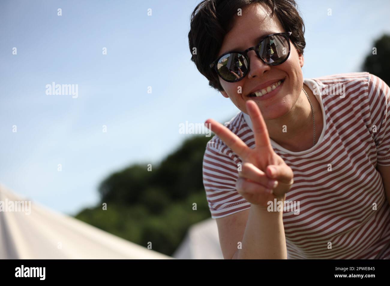 Young girl doing the peace sign at festival Stock Photo - Alamy