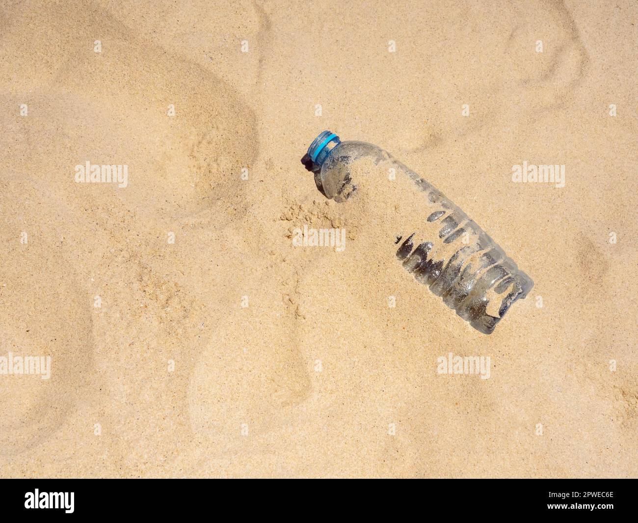 Plastic bottle on sandy beach, top view. Empty uncapped used plastic ...