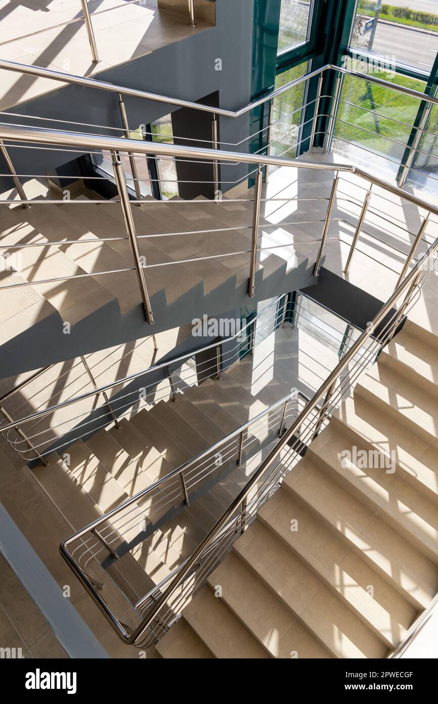 Stairs in a concrete office building in neutral tones, covered with ...