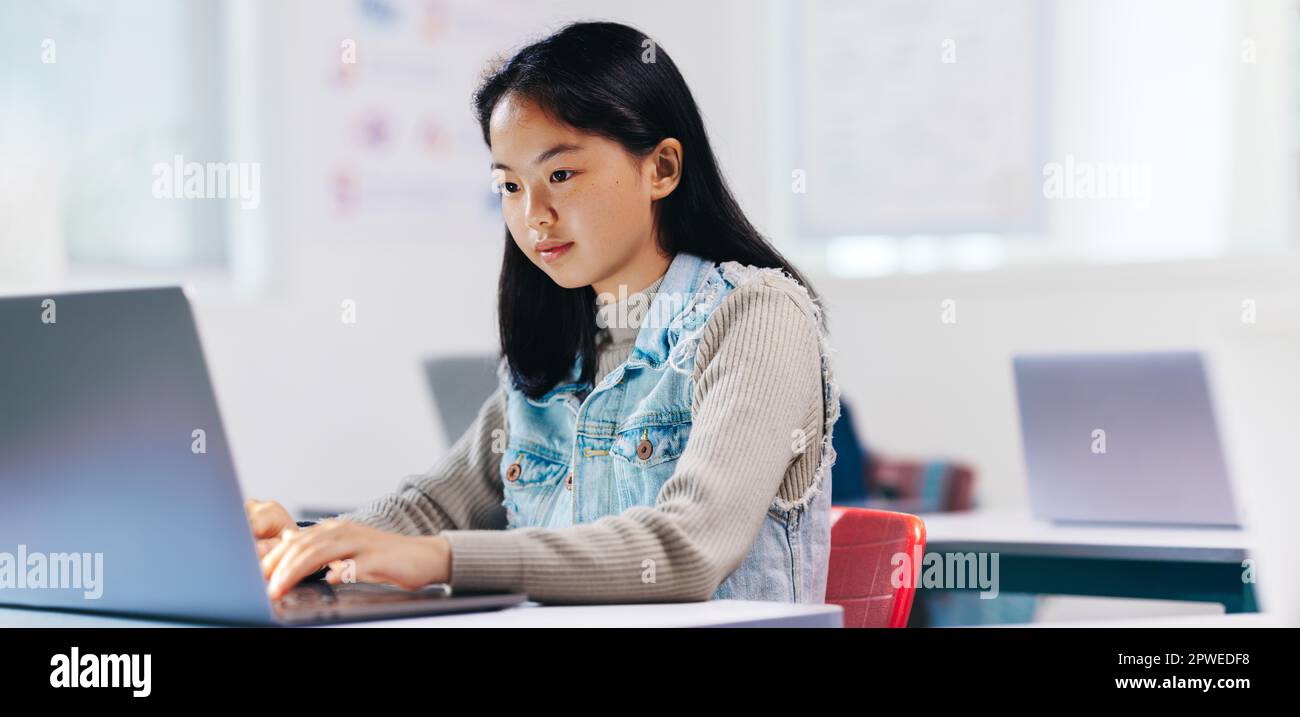 Female student taking on a computer programming task in a classroom ...