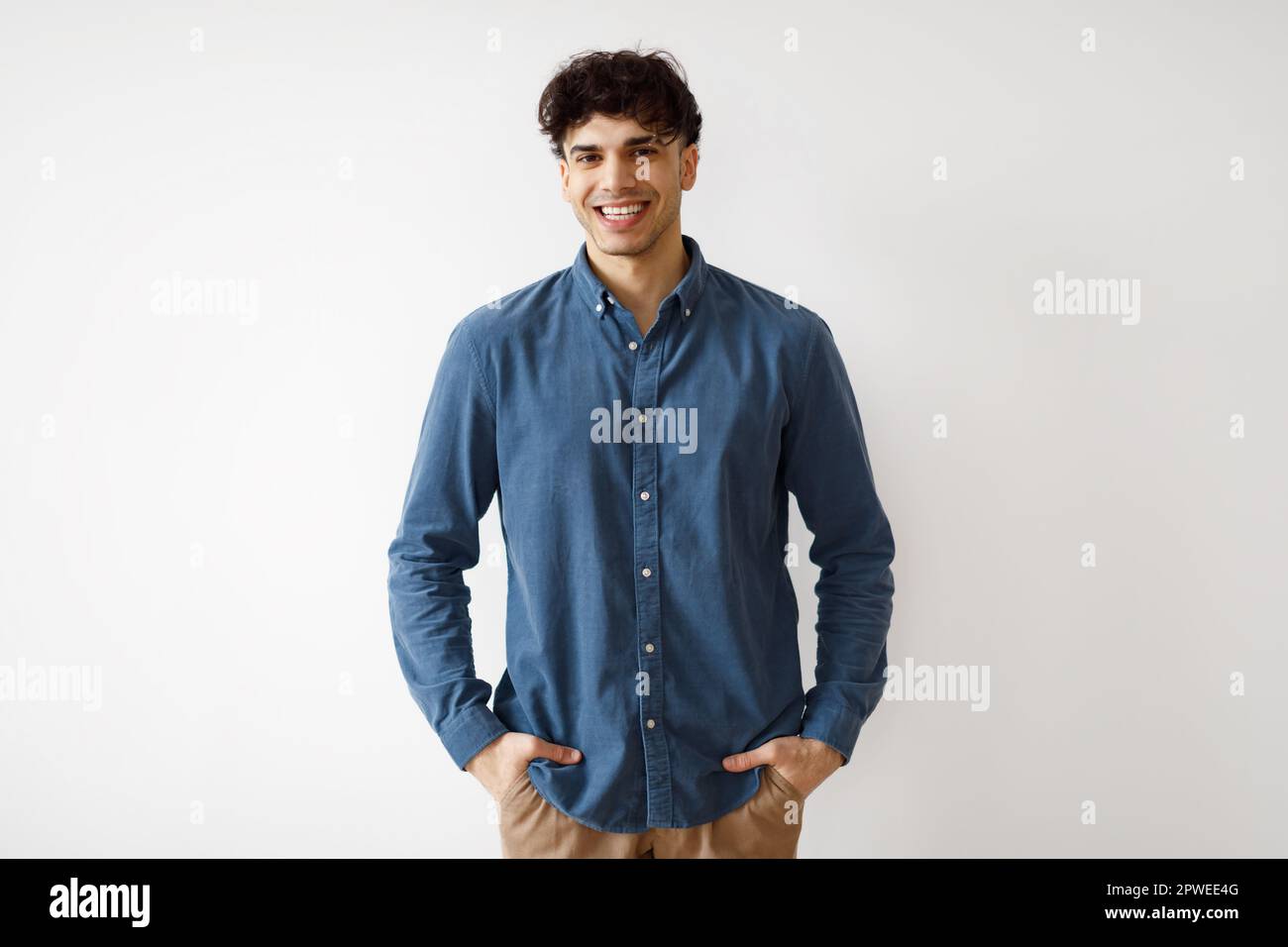 Happy Middle Eastern Young Man Smiling Standing Near White Wall Stock ...