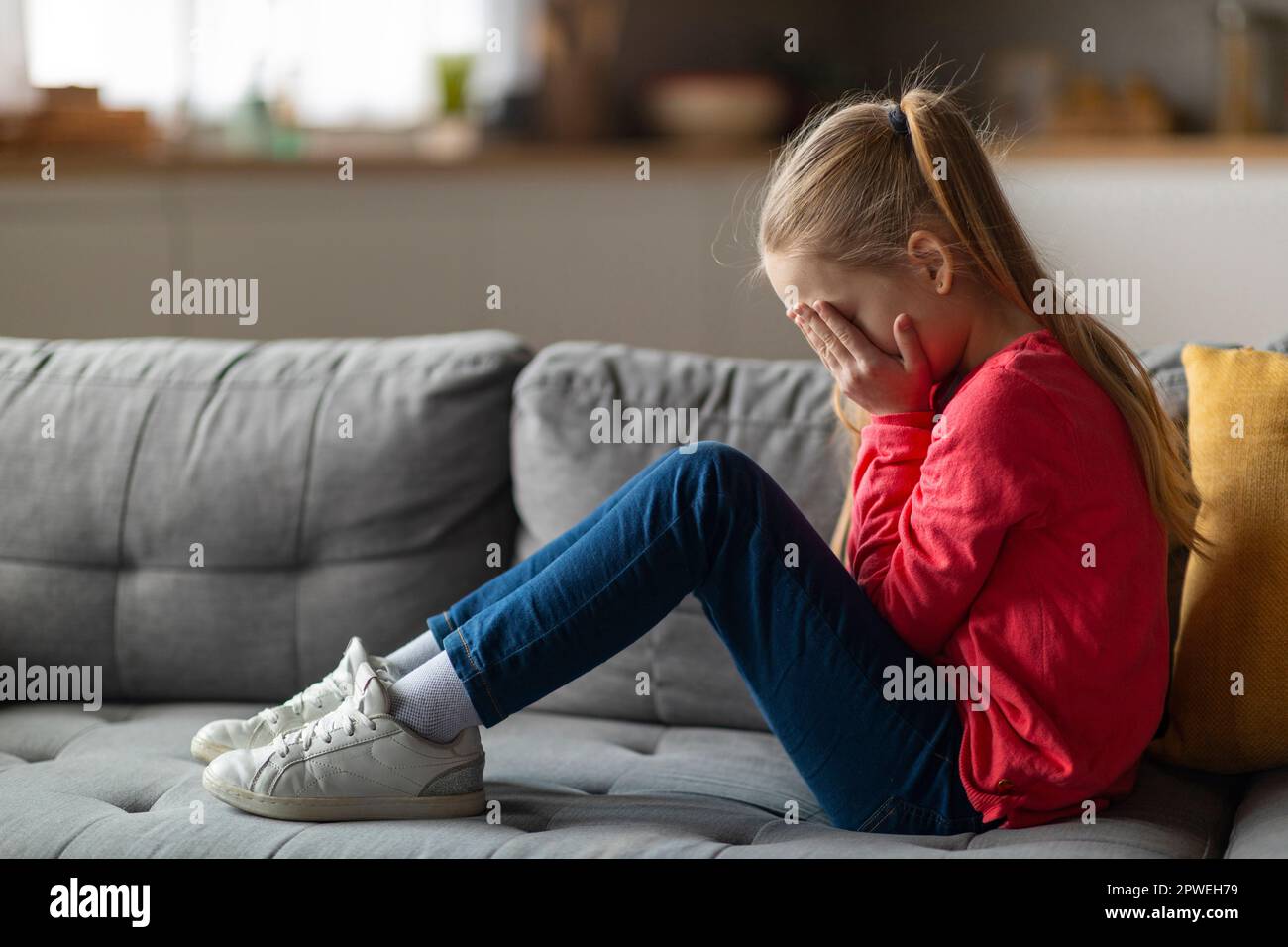 Portrait Of Crying Little Girl Sitting On Couch At Home Stock Photo - Alamy