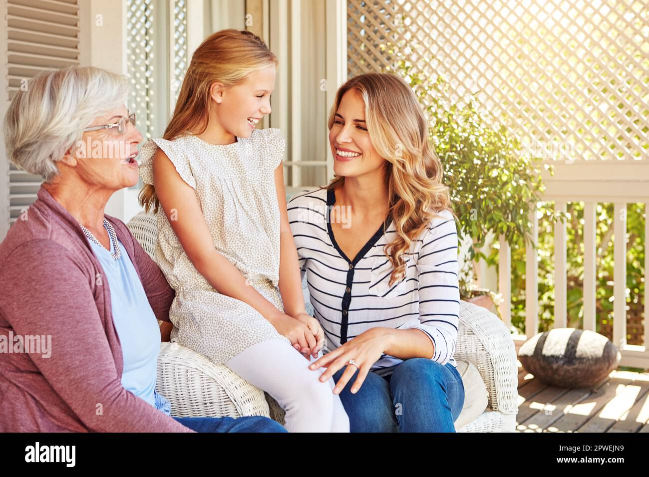 Three generations of family women. a young girl sitting outside with ...