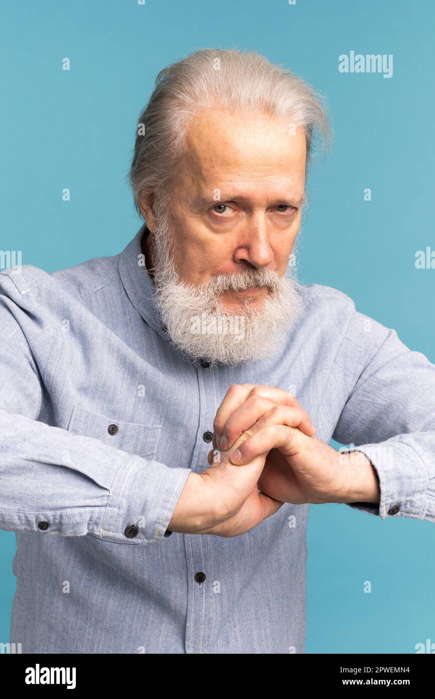 Portrait of angry pissed off bad senior mature man on blue background ...