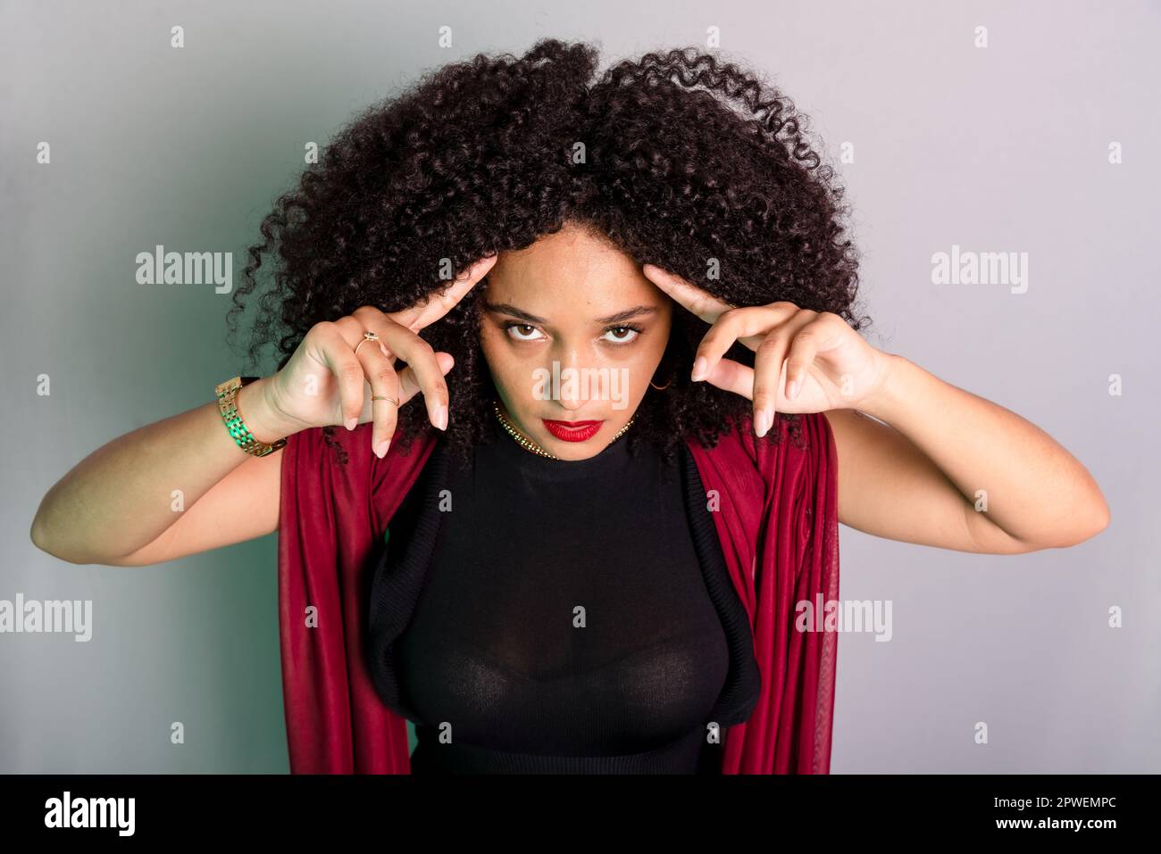 Beautiful young woman touching her hair with a red cloth. studio ...