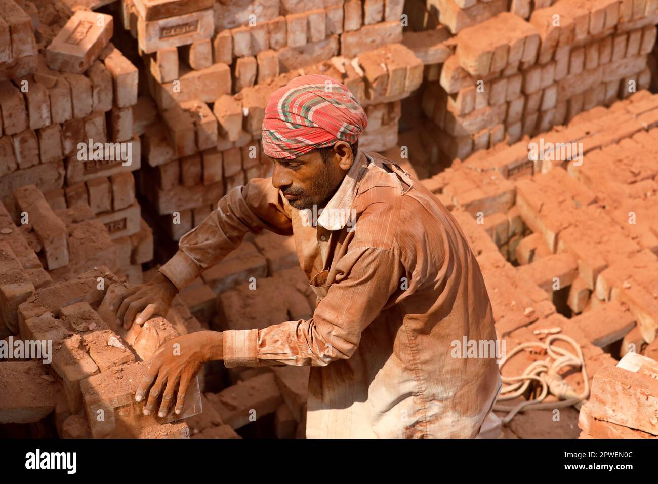 Dhaka, Bangladesh - April 30, 2023: Bangladeshi worker carries bricks ...